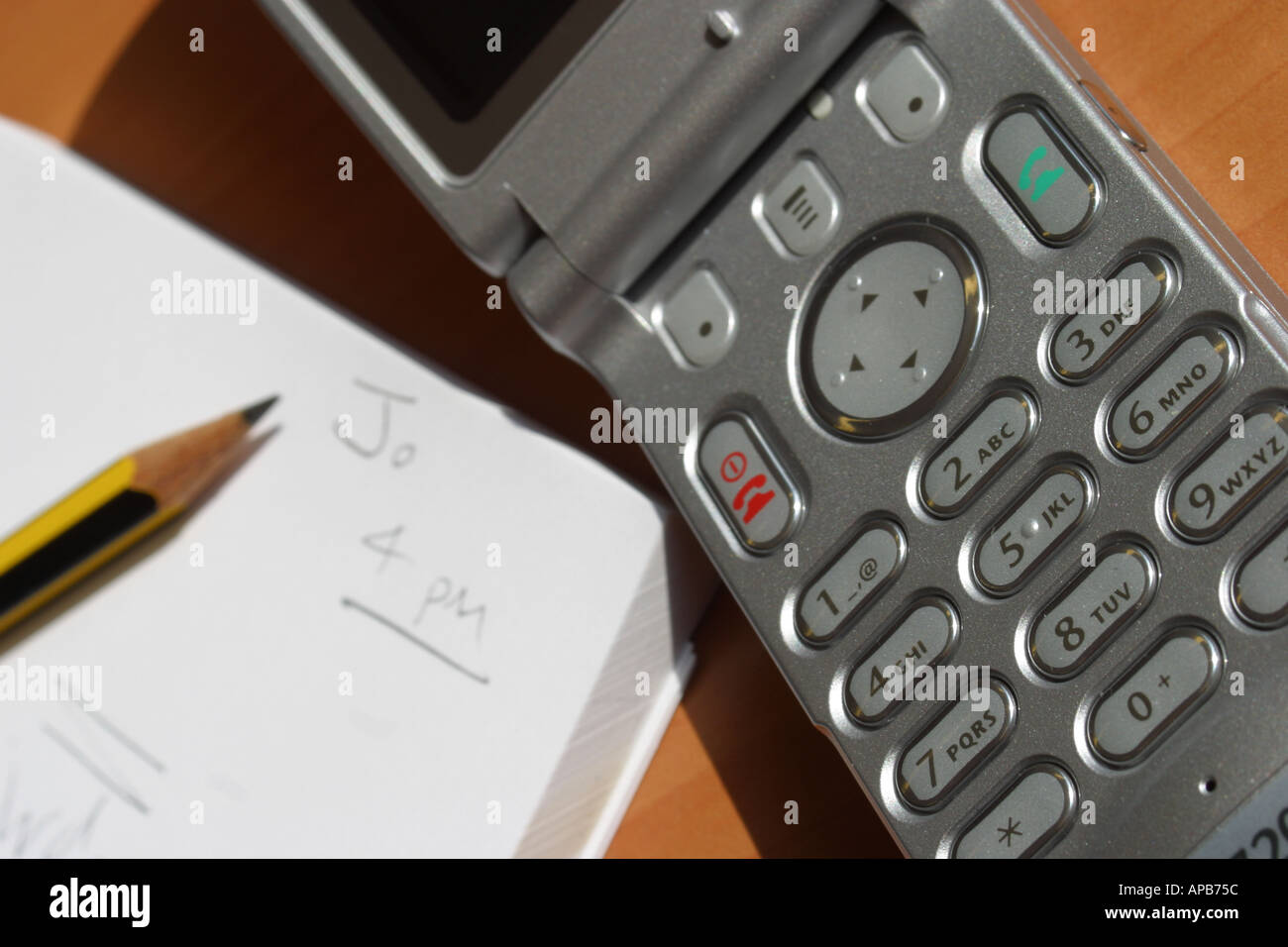 Mobile phone telephone with display screen notepad and pencil on an ...