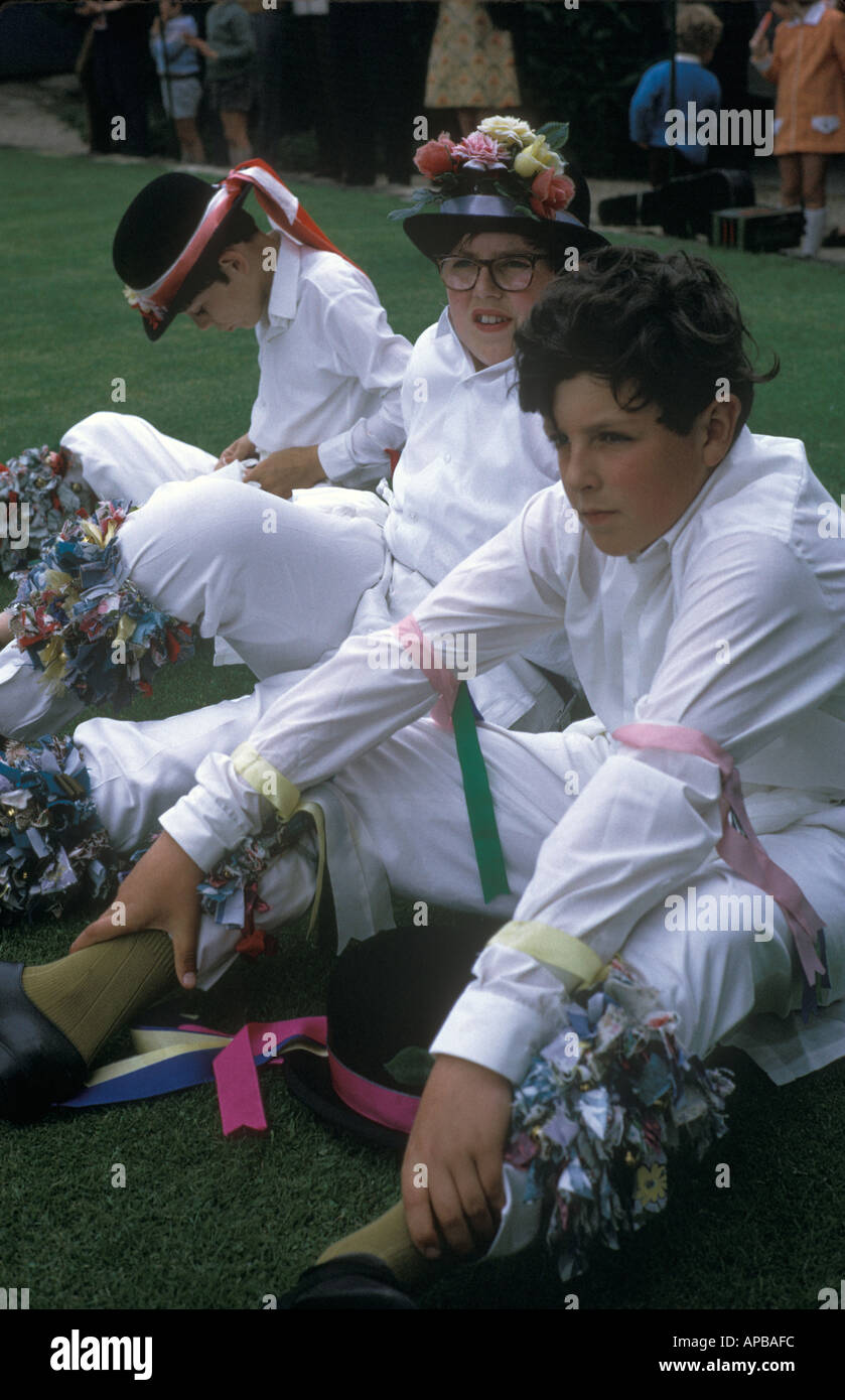 Teenage young Morris Dancers sitting out a dance watching parents ...