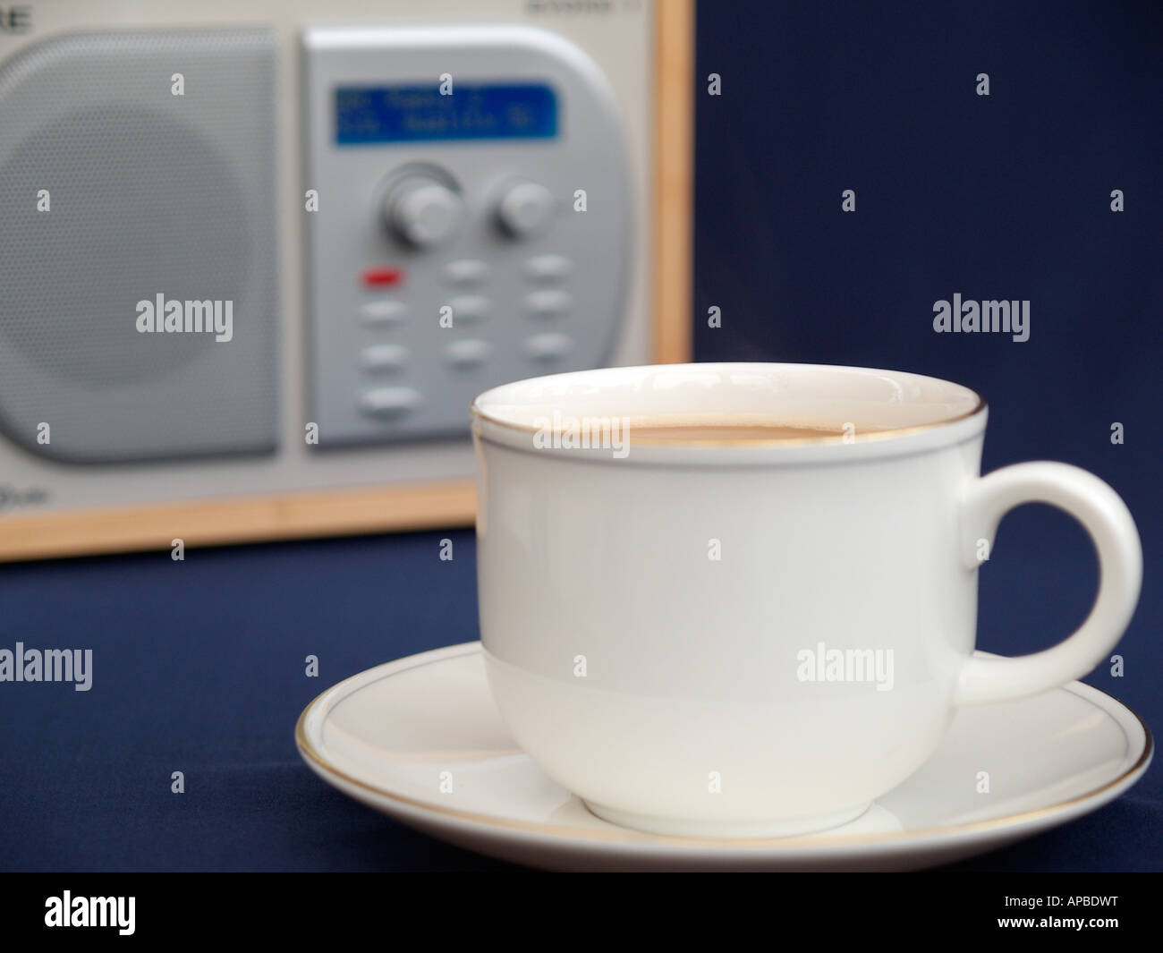 WHITE CHINA COFFEE CUP and SAUCER with DAB digital radio out of focus ...