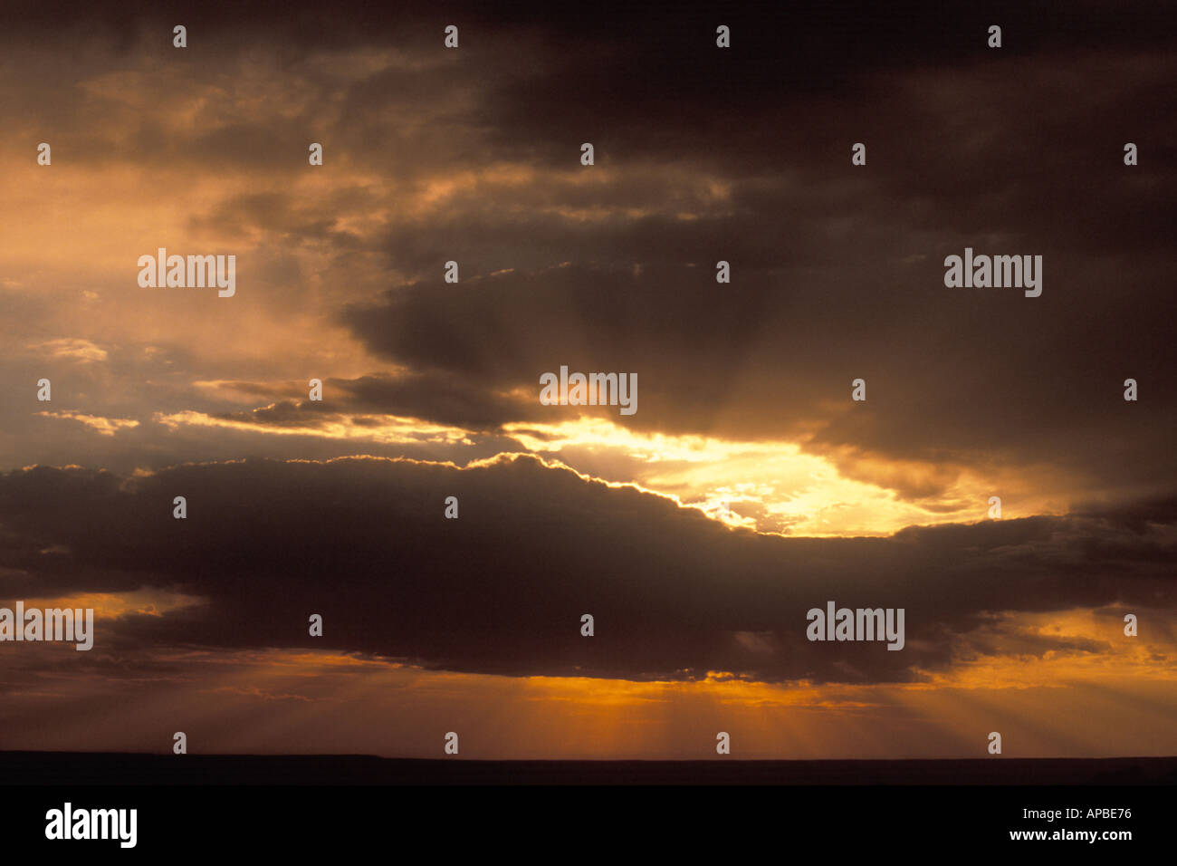 Sun setting through storm clouds Stock Photo - Alamy