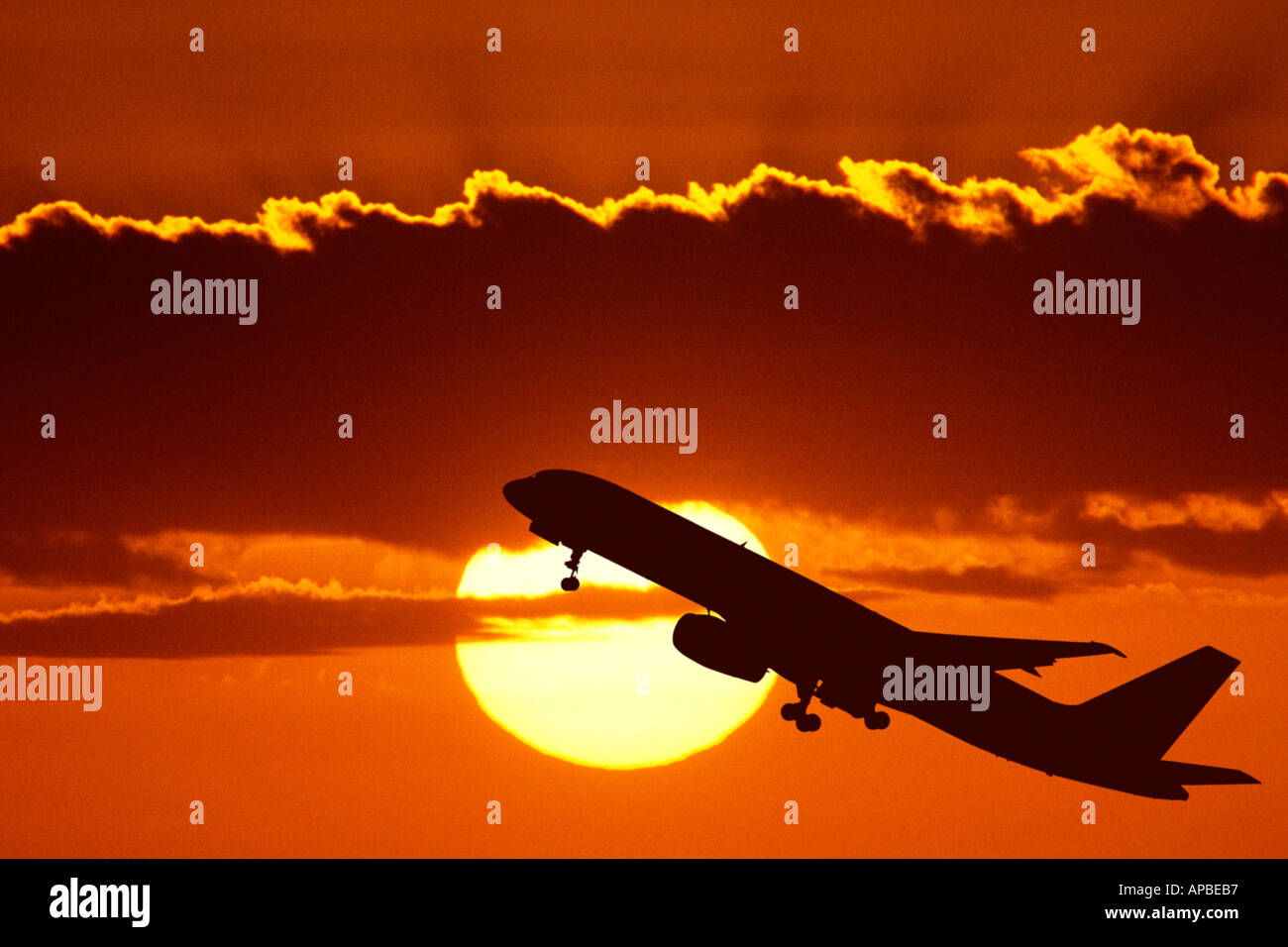 A commercial jet airliner takes off into the sunset sky Stock Photo - Alamy