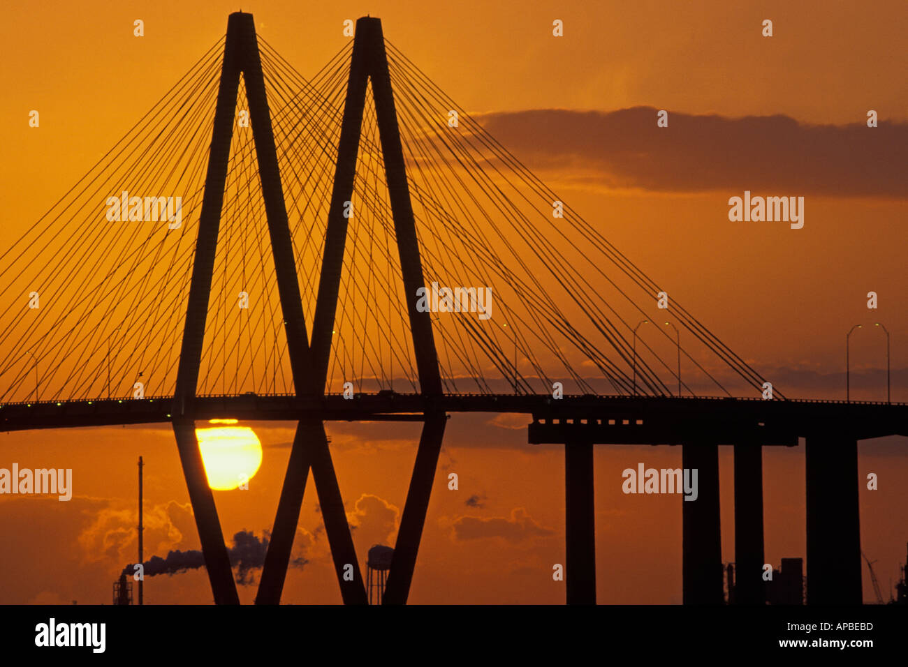 Sunset silhouette of the Fred Hartman Bridge over the Houston ship ...