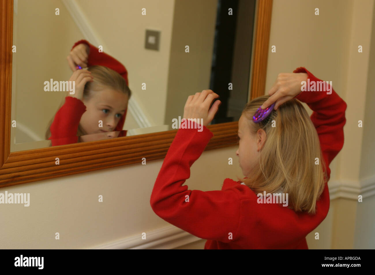 Young girl getting herself ready by combing her hair Stock Photo - Alamy