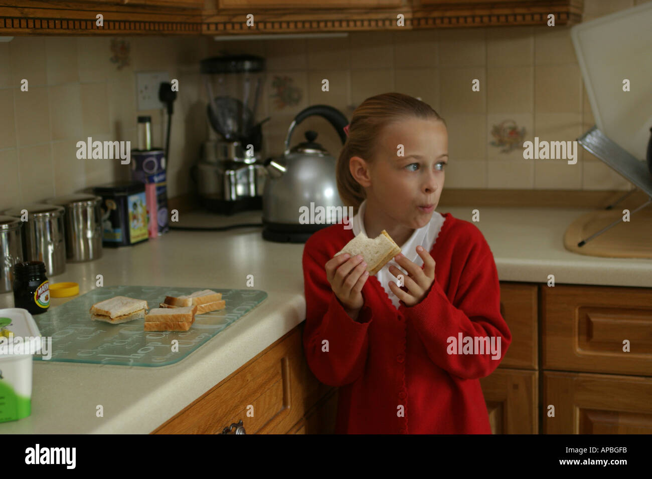 School girl eating a sandwich in her kitchen Stock Photo - Alamy