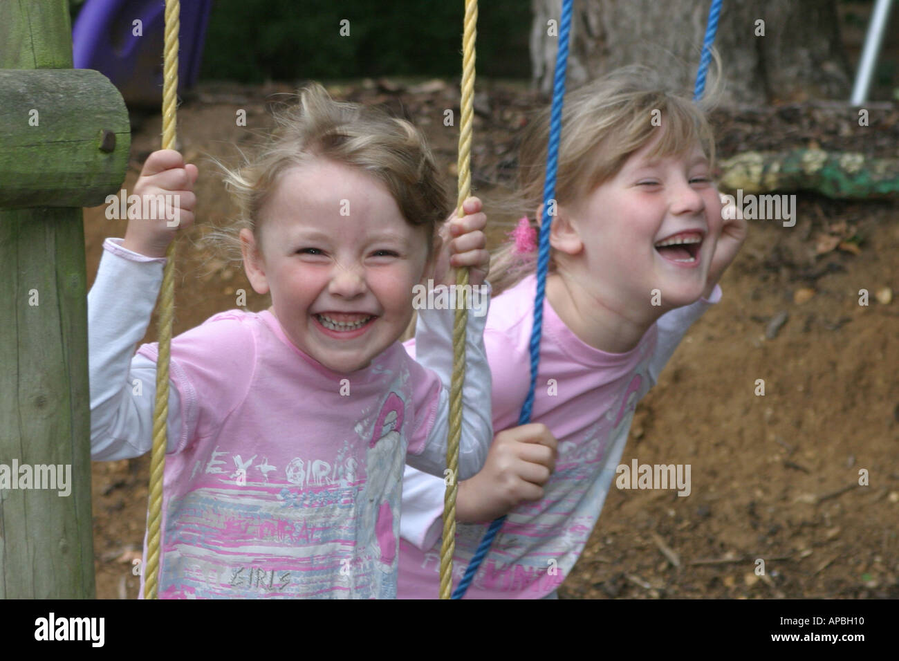Two girls swinging on swings hi-res stock photography and images - Alamy