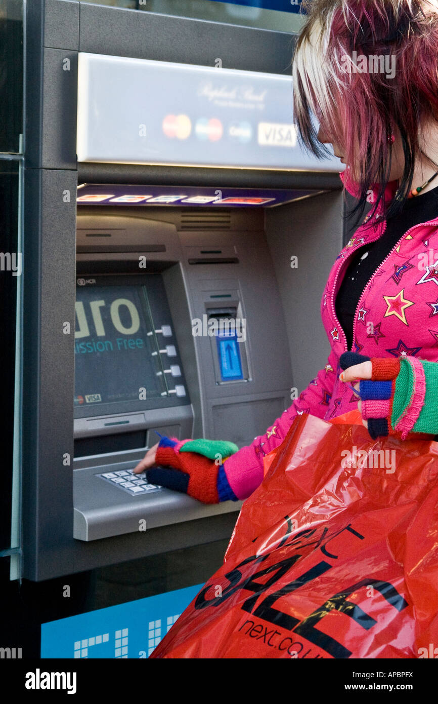 January sales shopper tapping in her pin number at Bank`s ATM cash ...