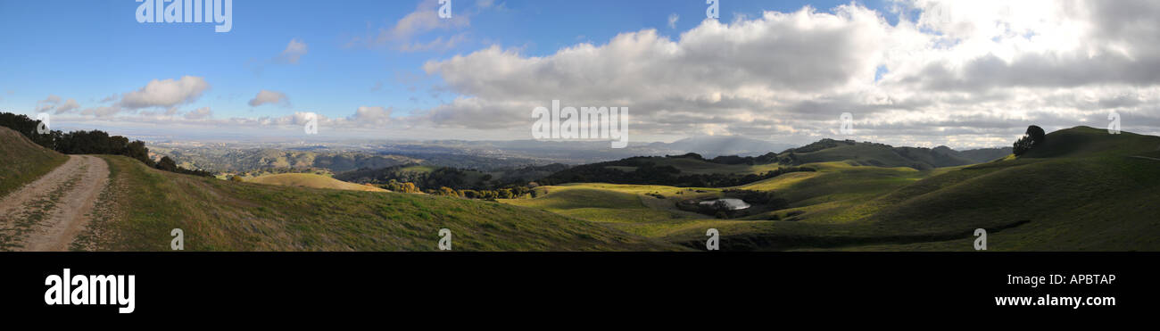 a panoramic view green hills dirt road Stock Photo - Alamy