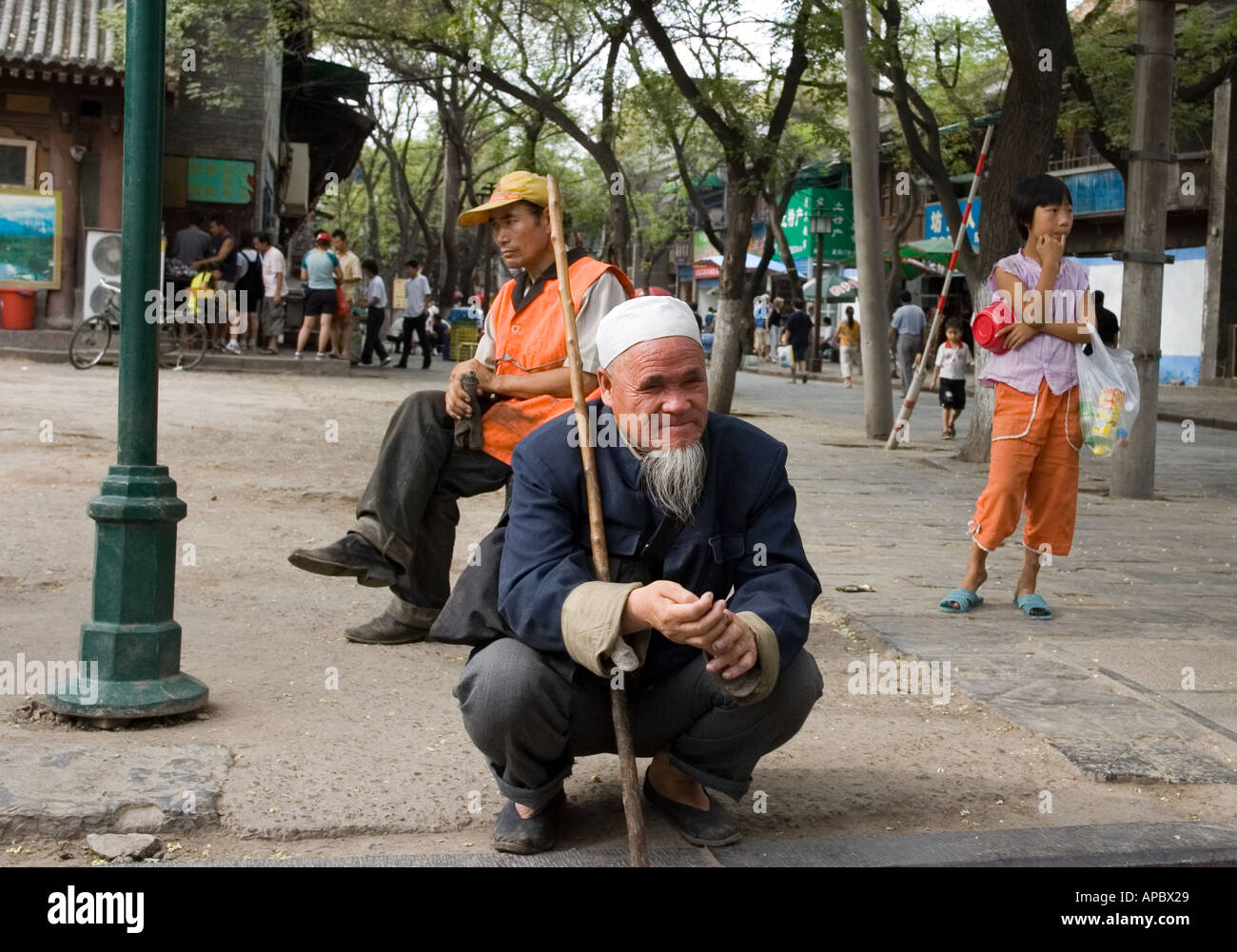 Local old man resting in squatting position in a street, Xi'an, China ...