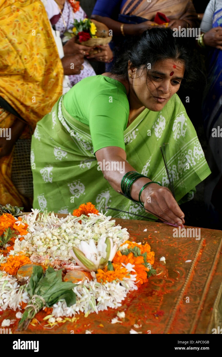 Hindu lady placing incense at Chammundeswari silver feet, Mysore, India ...