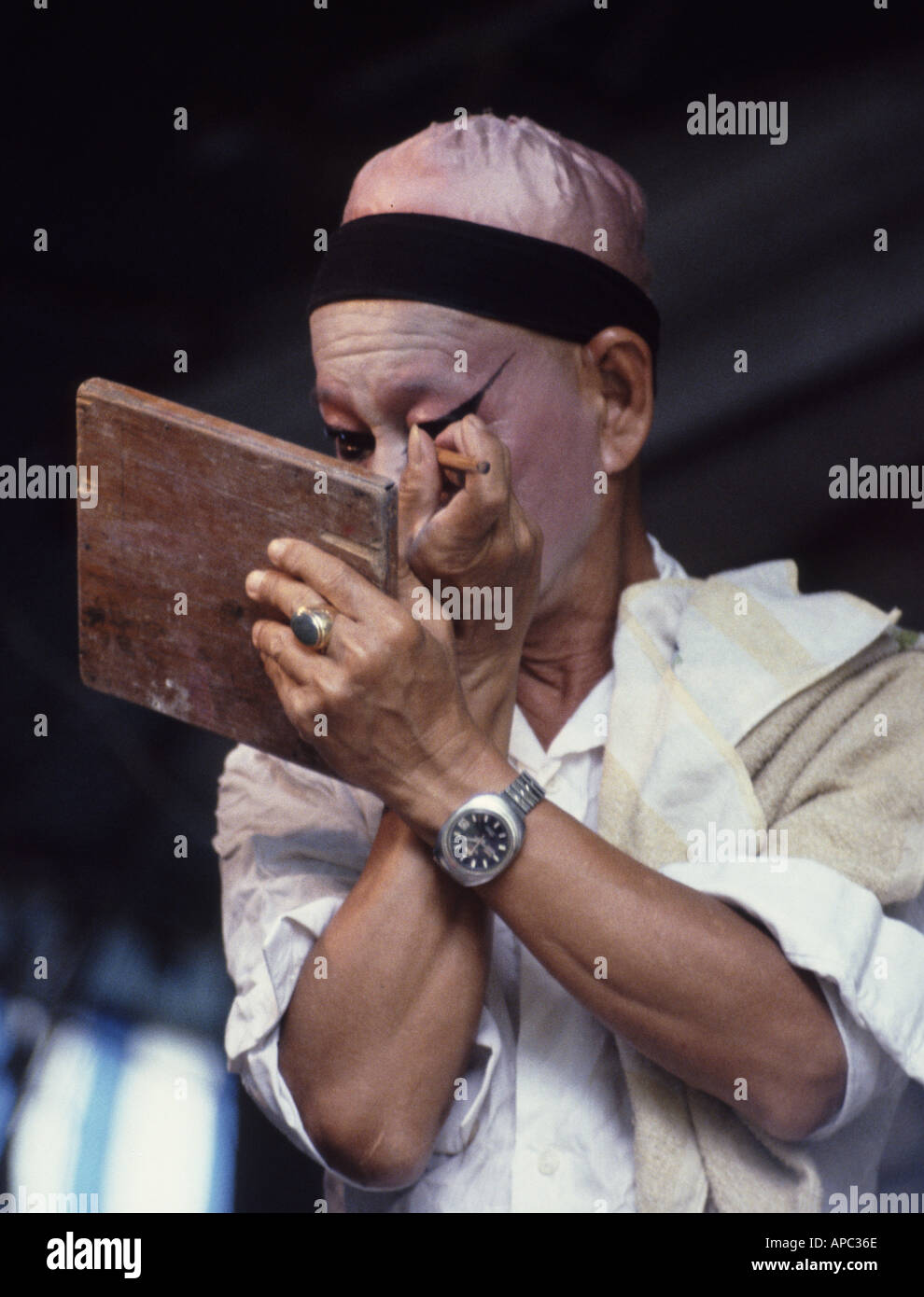 Chinese opera performer applying makeup before performance in Singapore ...