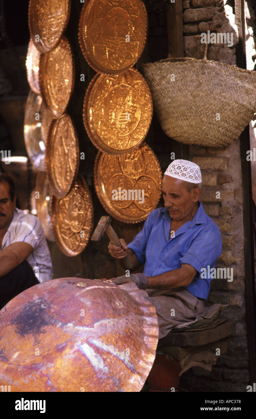 Iraqi craftsman working on large brass plate which will be decorated ...