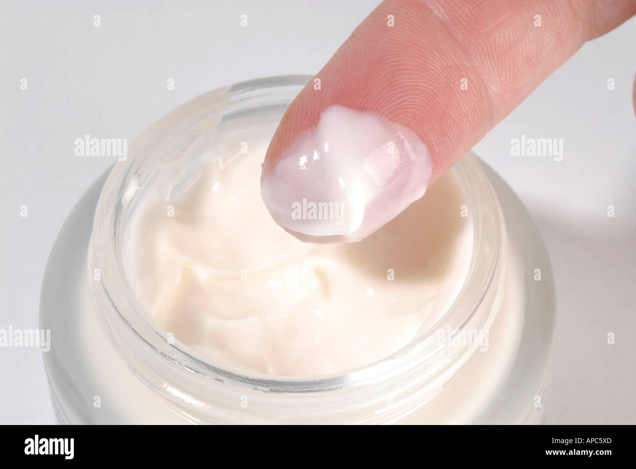 Finger in skin cream pot Stock Photo - Alamy