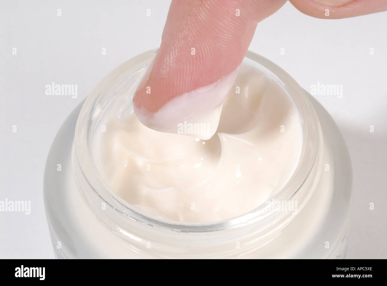 Finger in skin cream pot Stock Photo - Alamy