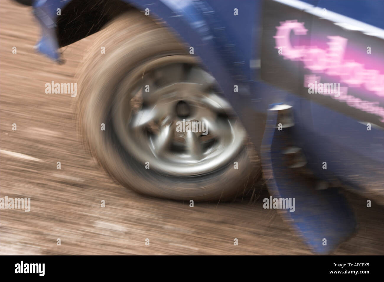Close up of rally car front wheel speeding passed Motion blur gives ...