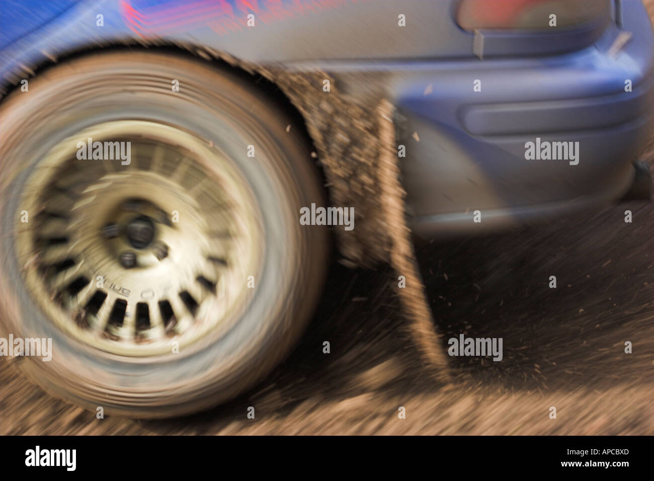 Close up of rally car rear wheel speeding passed Motion blur gives ...