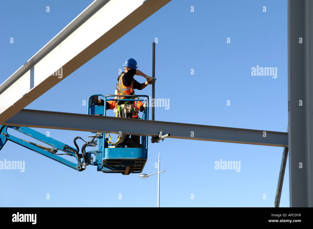 Construction worker building scaffolding on a steel fabricated building ...