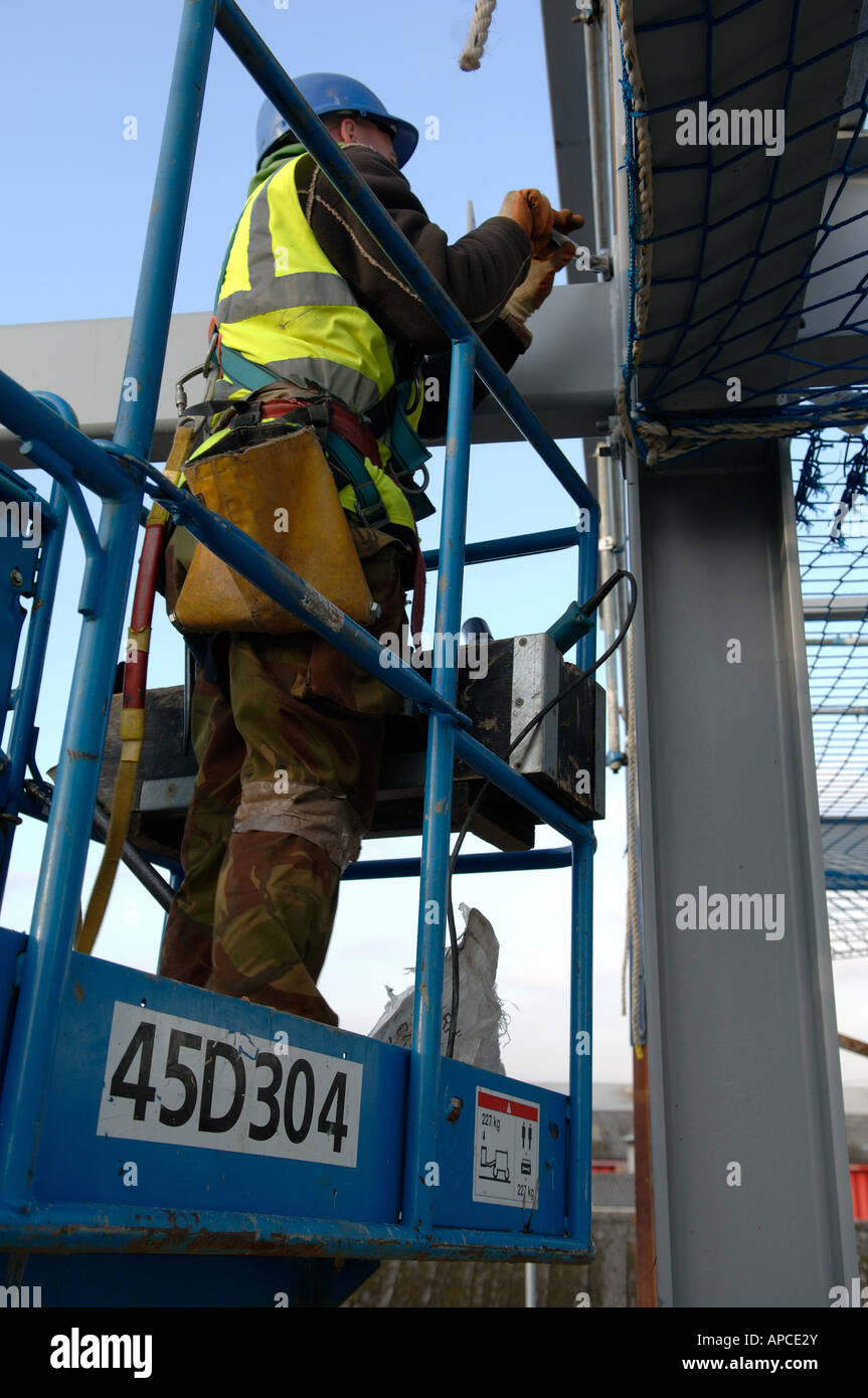 Construction worker bolting steel beams together on steel fabricated ...