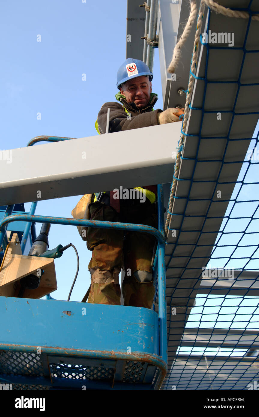 Construction worker bolting steel beams together on steel fabricated ...