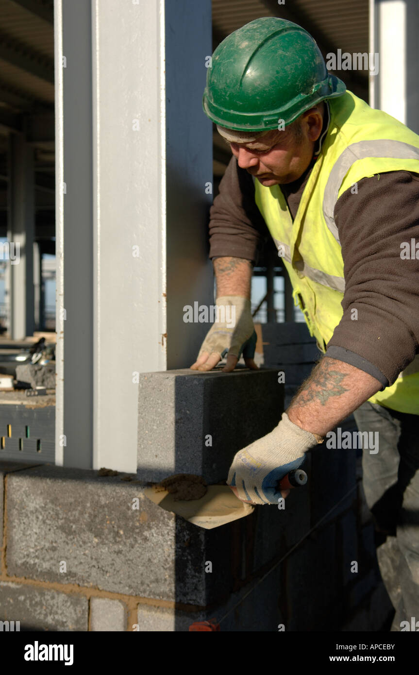 Construction worker building breeze block wall Stock Photo - Alamy