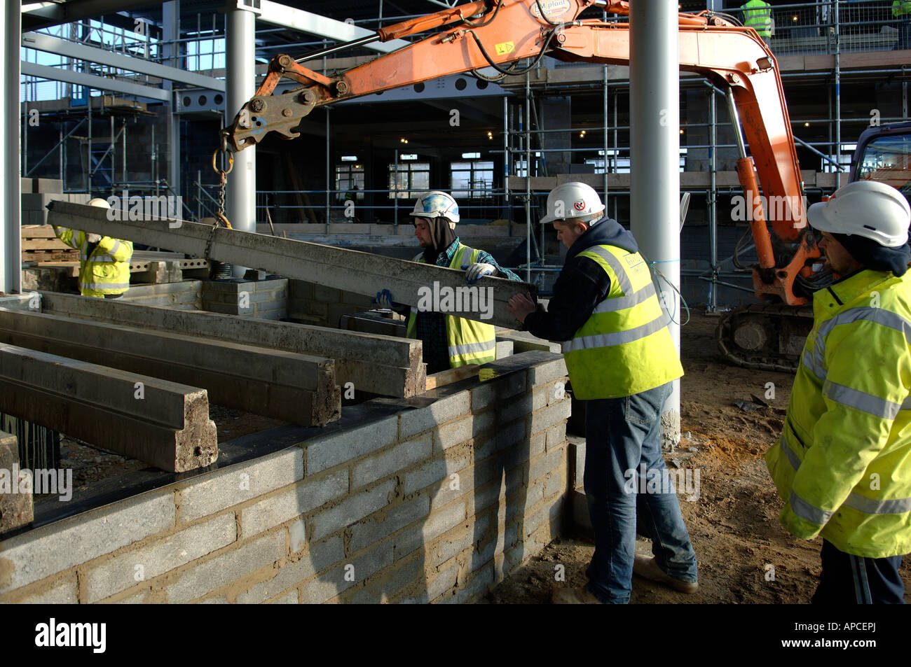 Construction workers laying concrete beam flooring to new building ...