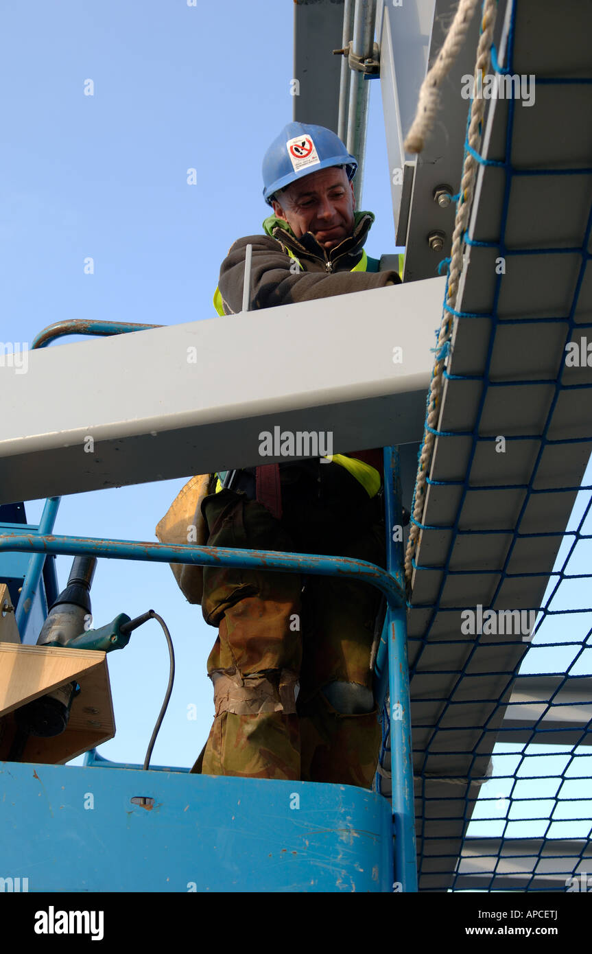 Construction worker bolting steel beams together on steel fabricated ...