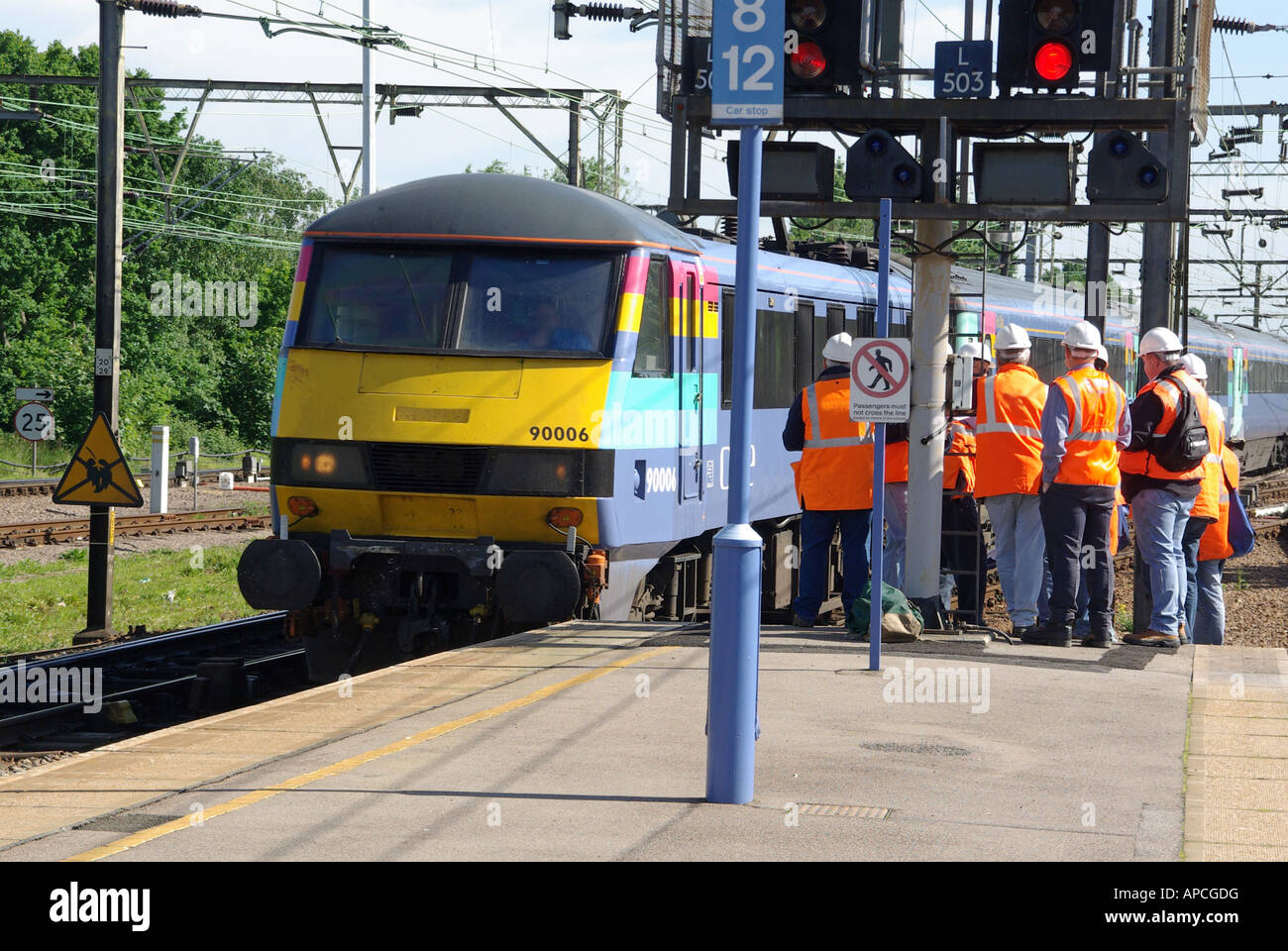 Group railway track maintenance staff in high visibility jackets wait ...