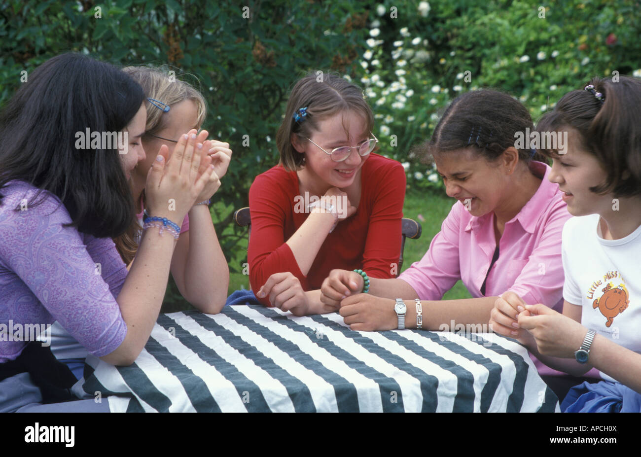 group of girls sitting around a table Stock Photo - Alamy