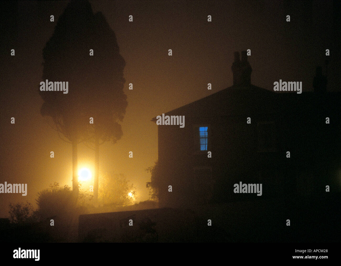 Fog at night with light in the window of a house Stock Photo - Alamy