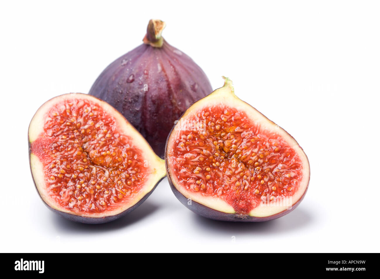 a whole and a halved fresh fig isolated on white background Stock Photo ...