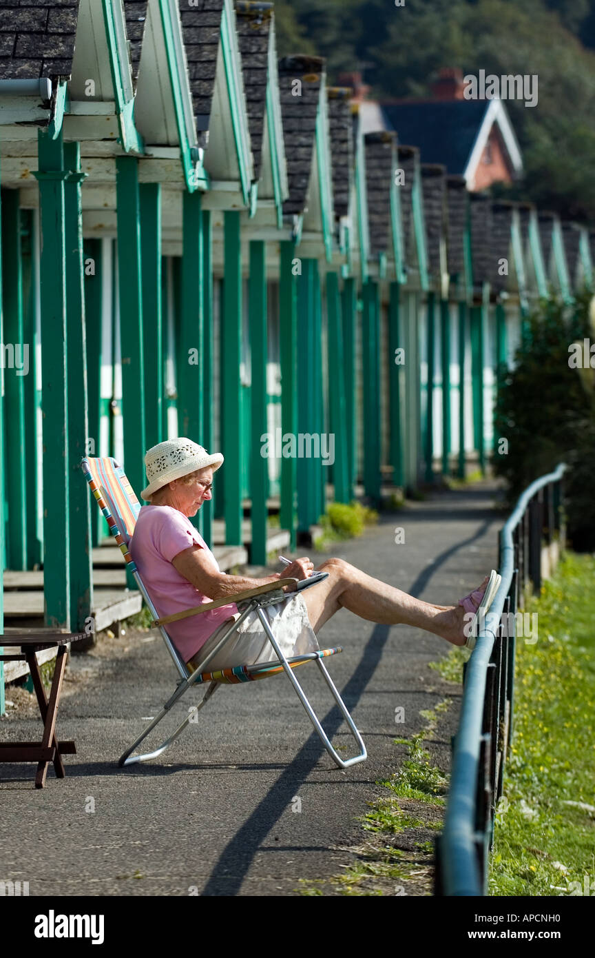 Lady relaxing outside beach hut hi-res stock photography and images - Alamy