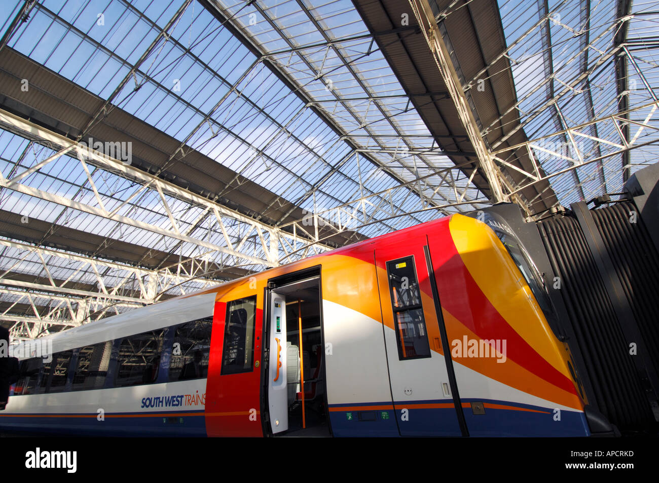 commuters on platforms next to trains at waterloo mainline station ...