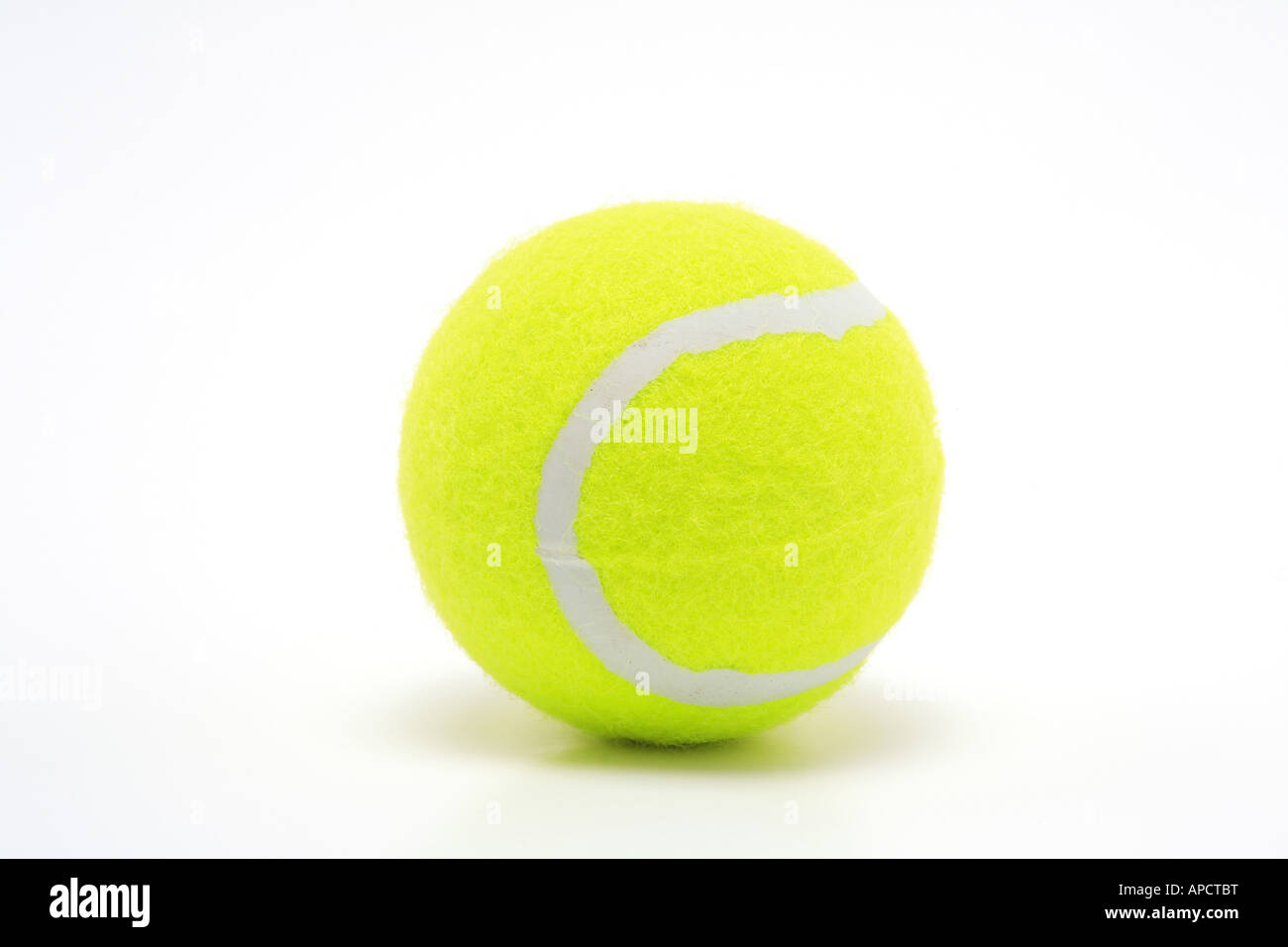 a single yellow tennis ball on white surface Stock Photo - Alamy
