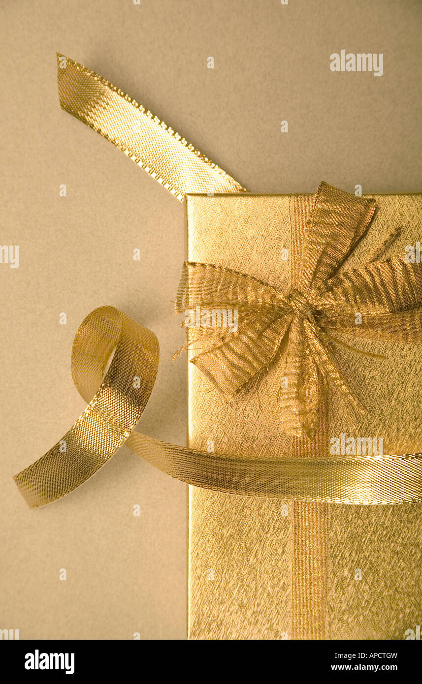 Gift wrapped with golden paper and ribbons Stock Photo - Alamy