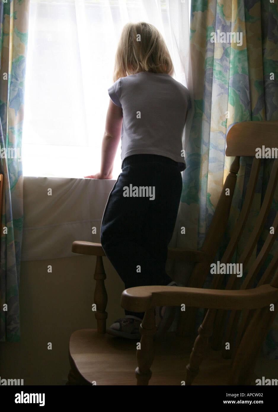 young girl peering through window Stock Photo - Alamy