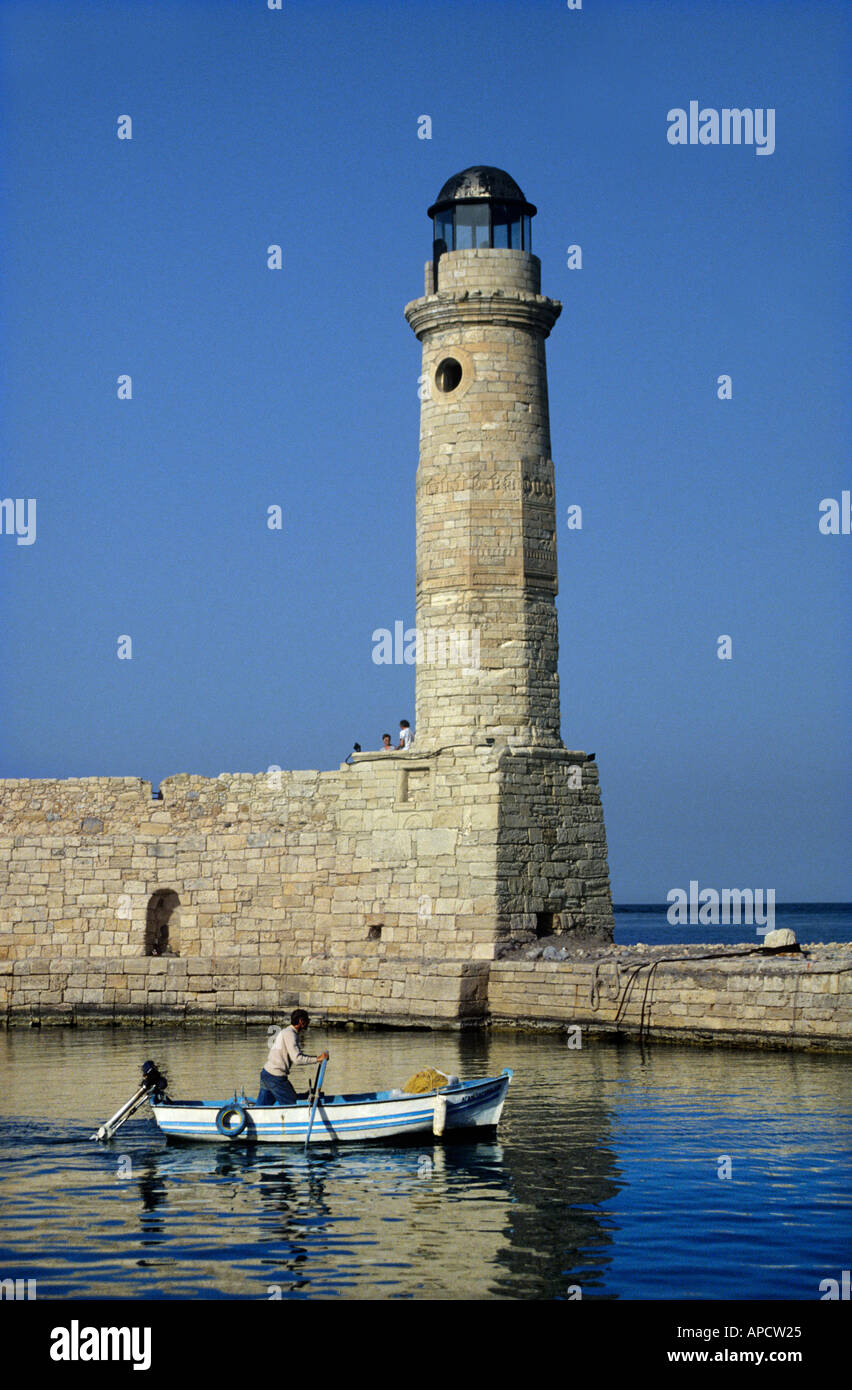 Lighthouse at harbour entrance with man rowing boat Rethymnon Crete ...