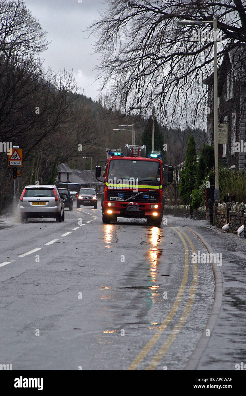 fire engine on a road on a wet winters day going to an emergency call ...