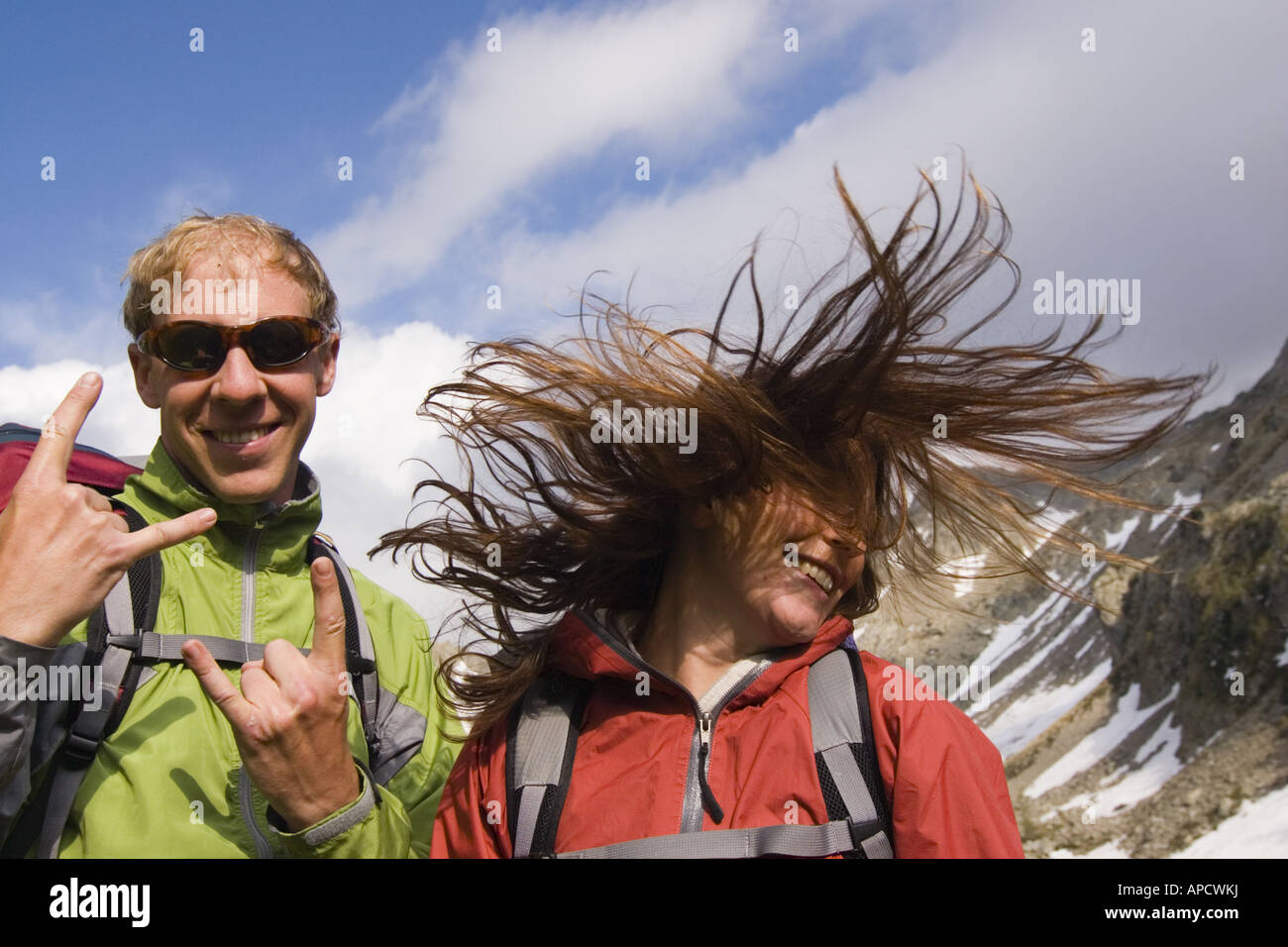 A woman tossing her hair as her boyfriend looks on while hiking near ...