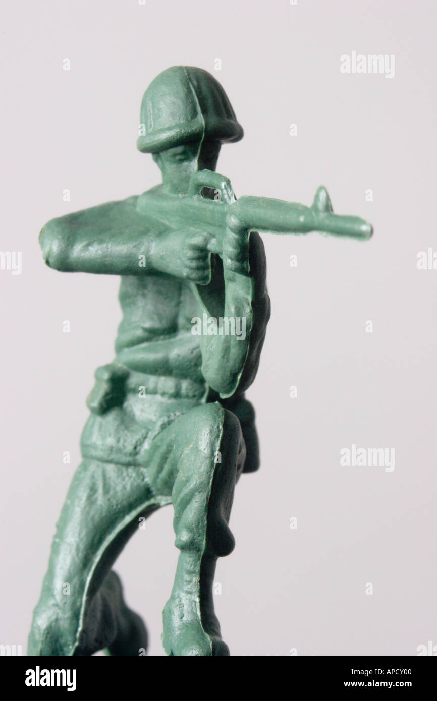 toy soldier which is standing upright and all alone on a white ...