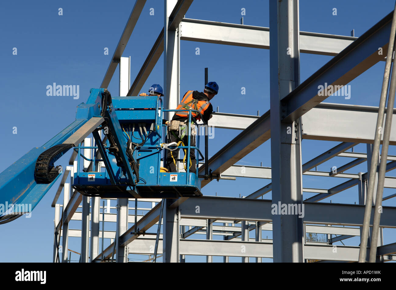 Construction worker building scaffolding on a steel fabricated building ...