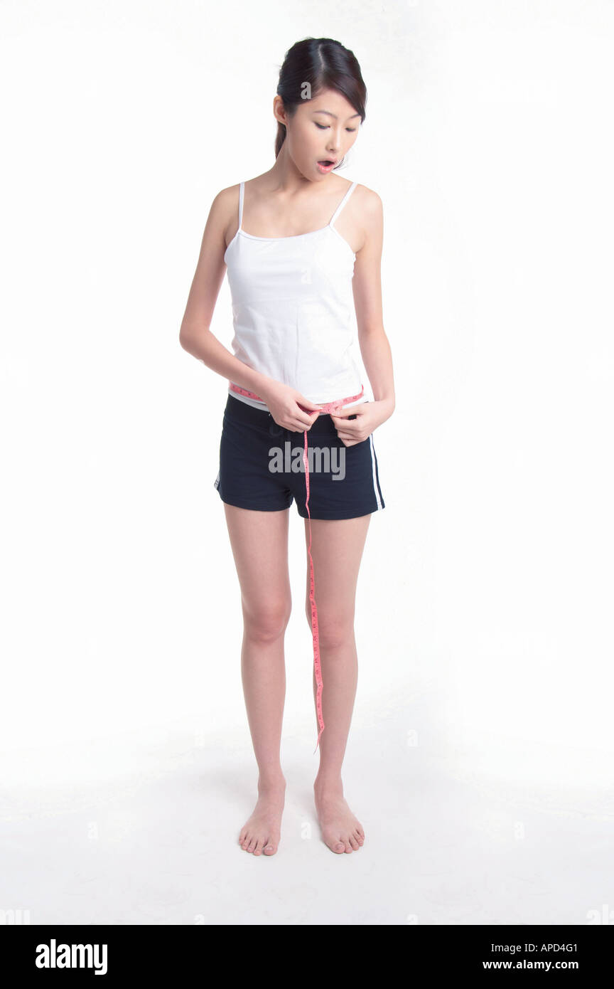 Young woman standing and measuring full length Stock Photo - Alamy