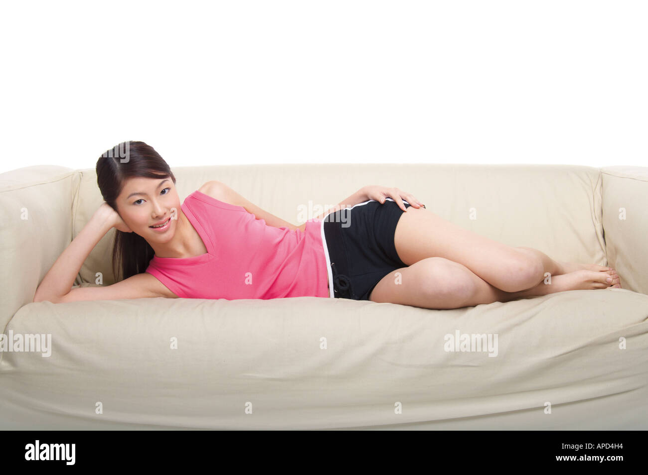 Young woman lying on sofa in side view Stock Photo - Alamy