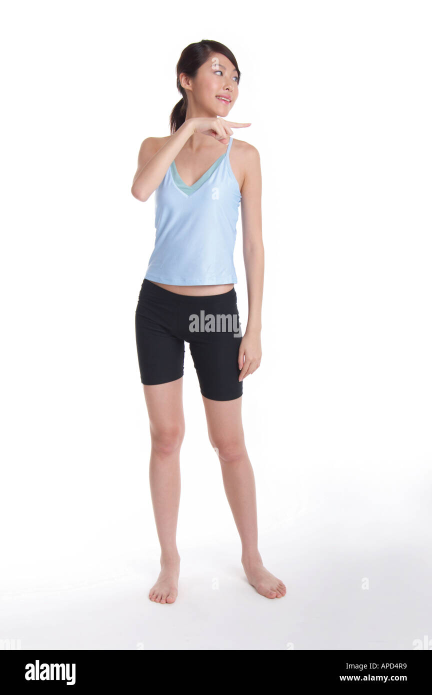 Young woman standing and pointing to right Stock Photo - Alamy