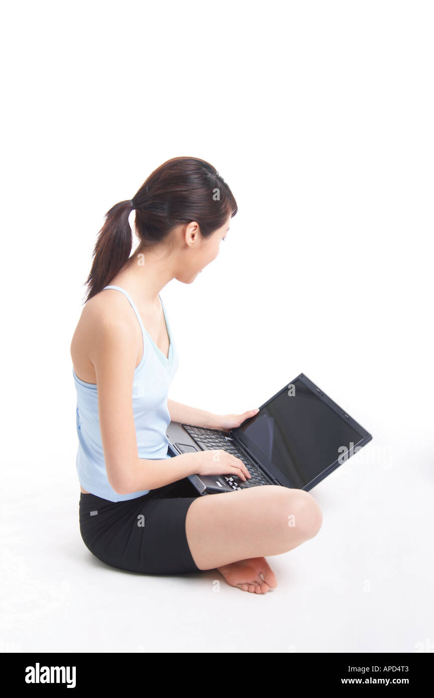 Young woman sitting and using notebook crossed legged Stock Photo - Alamy