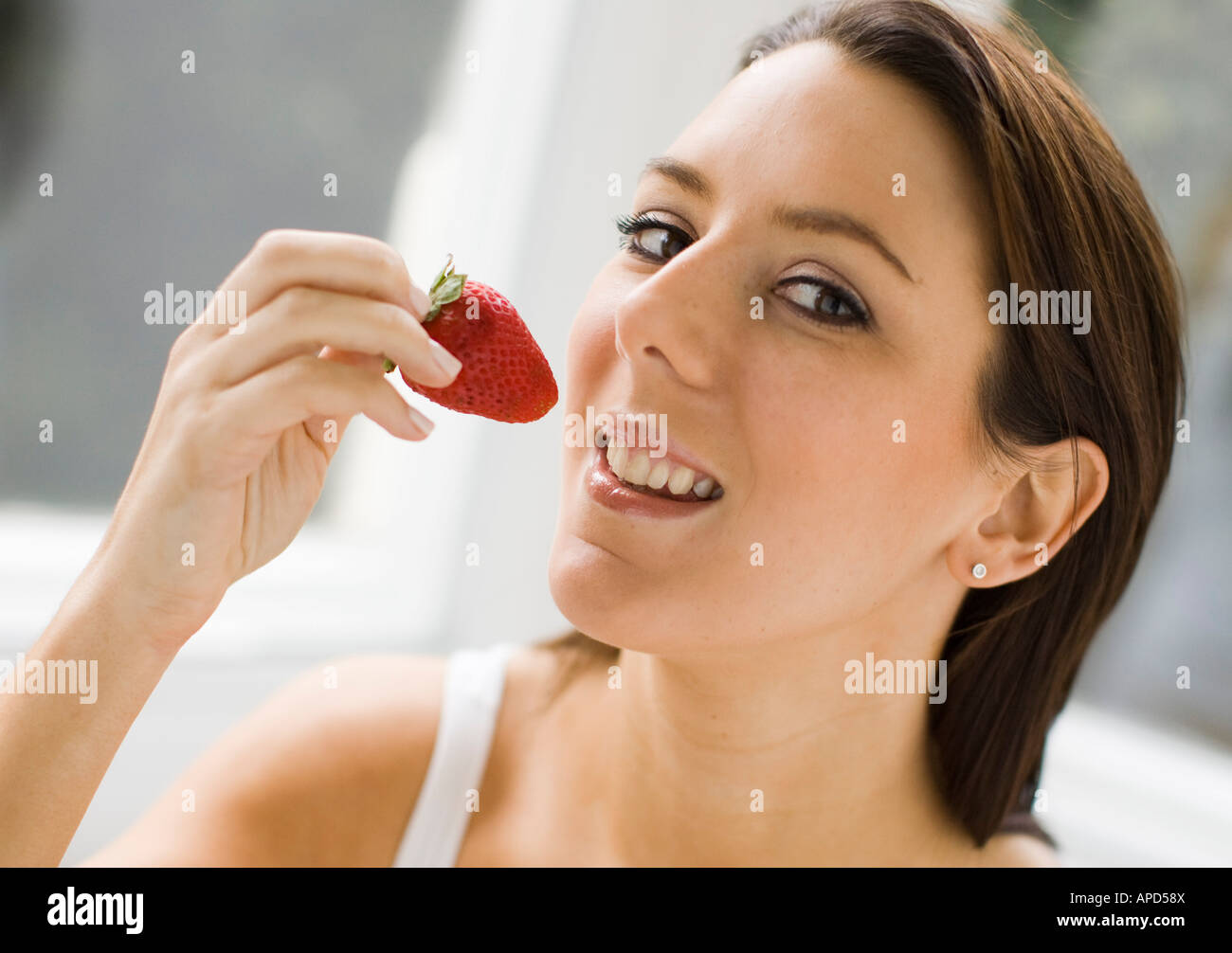 Woman eating a Strawberry Stock Photo - Alamy