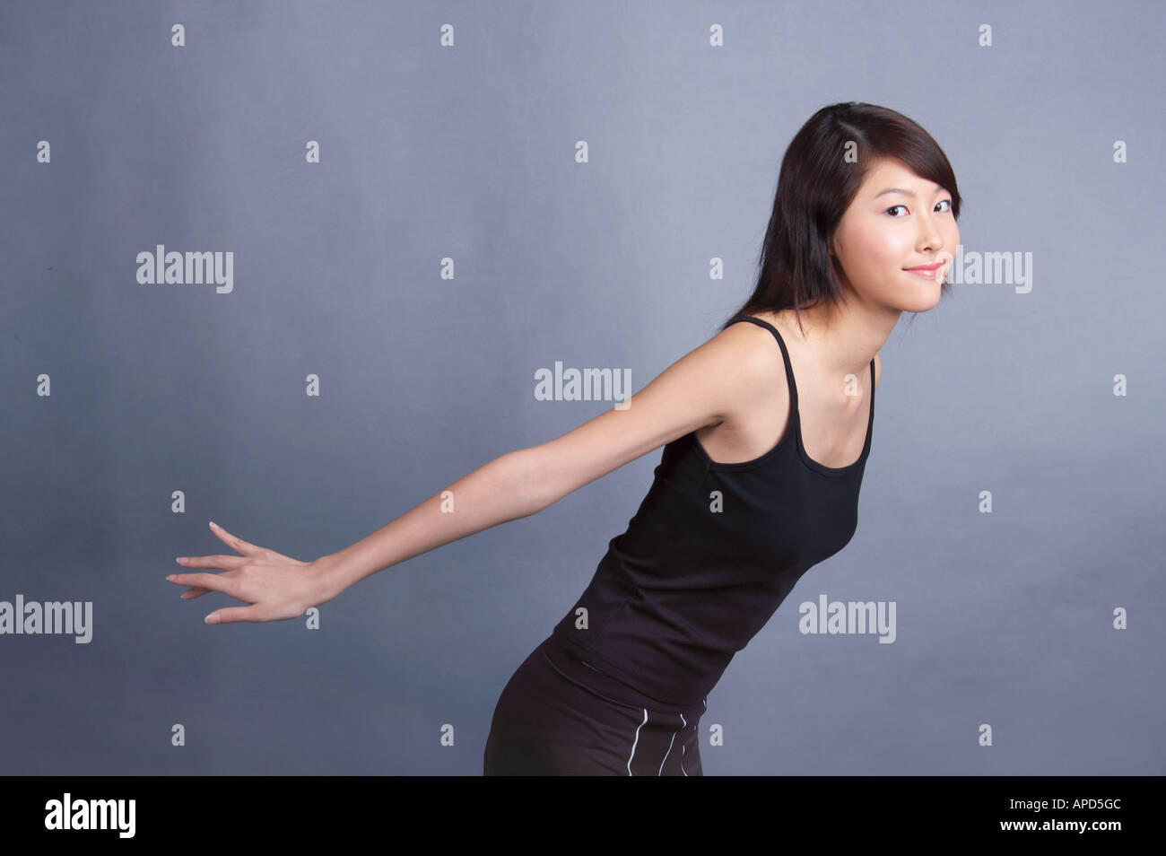 Young woman stretching arm bending forward Stock Photo - Alamy