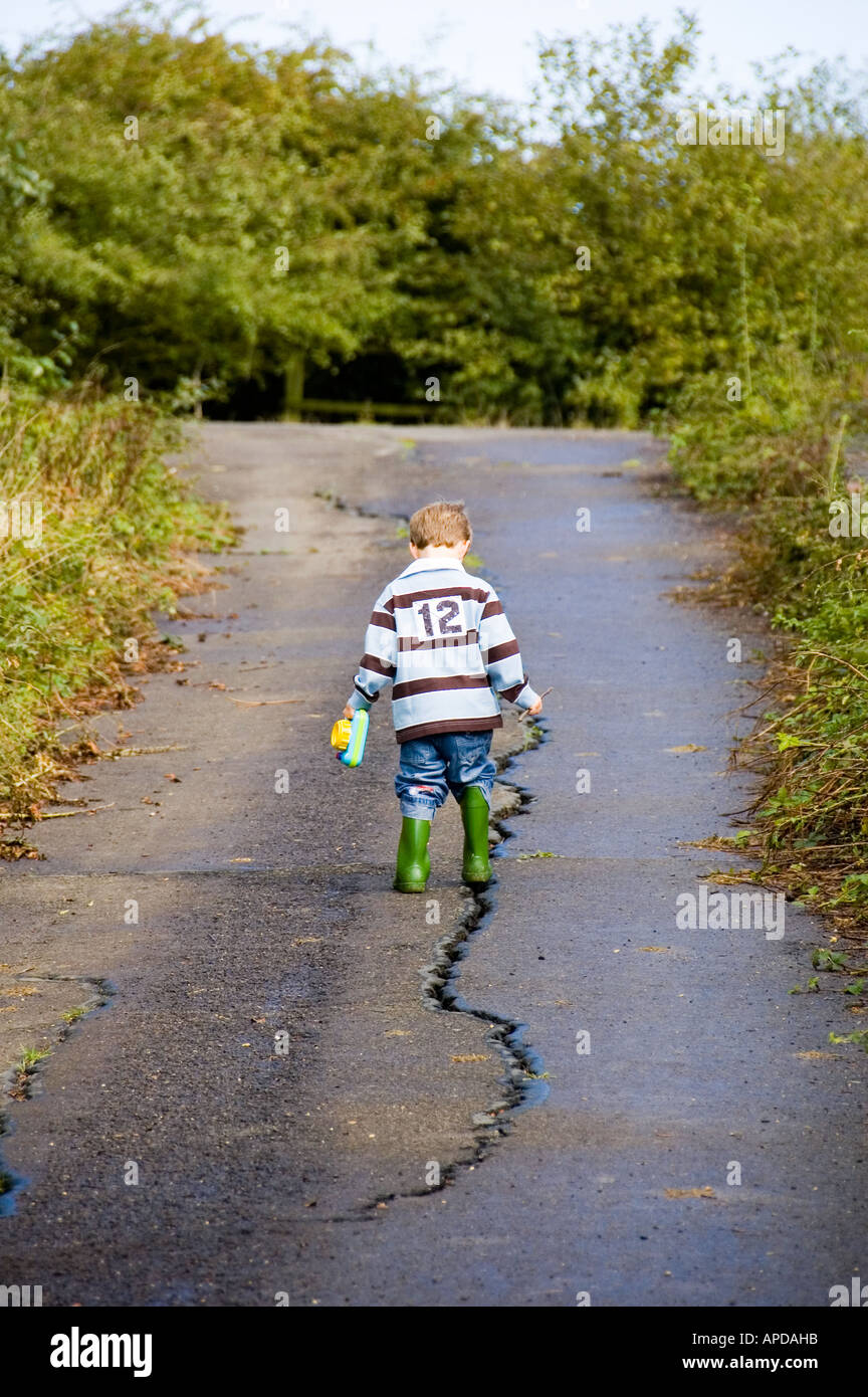 Small Child Walking along Crack in Road Surface Stock Photo - Alamy