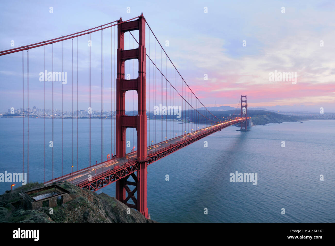 Golden Gate Brige with sunset colors in the background and ruins of old ...