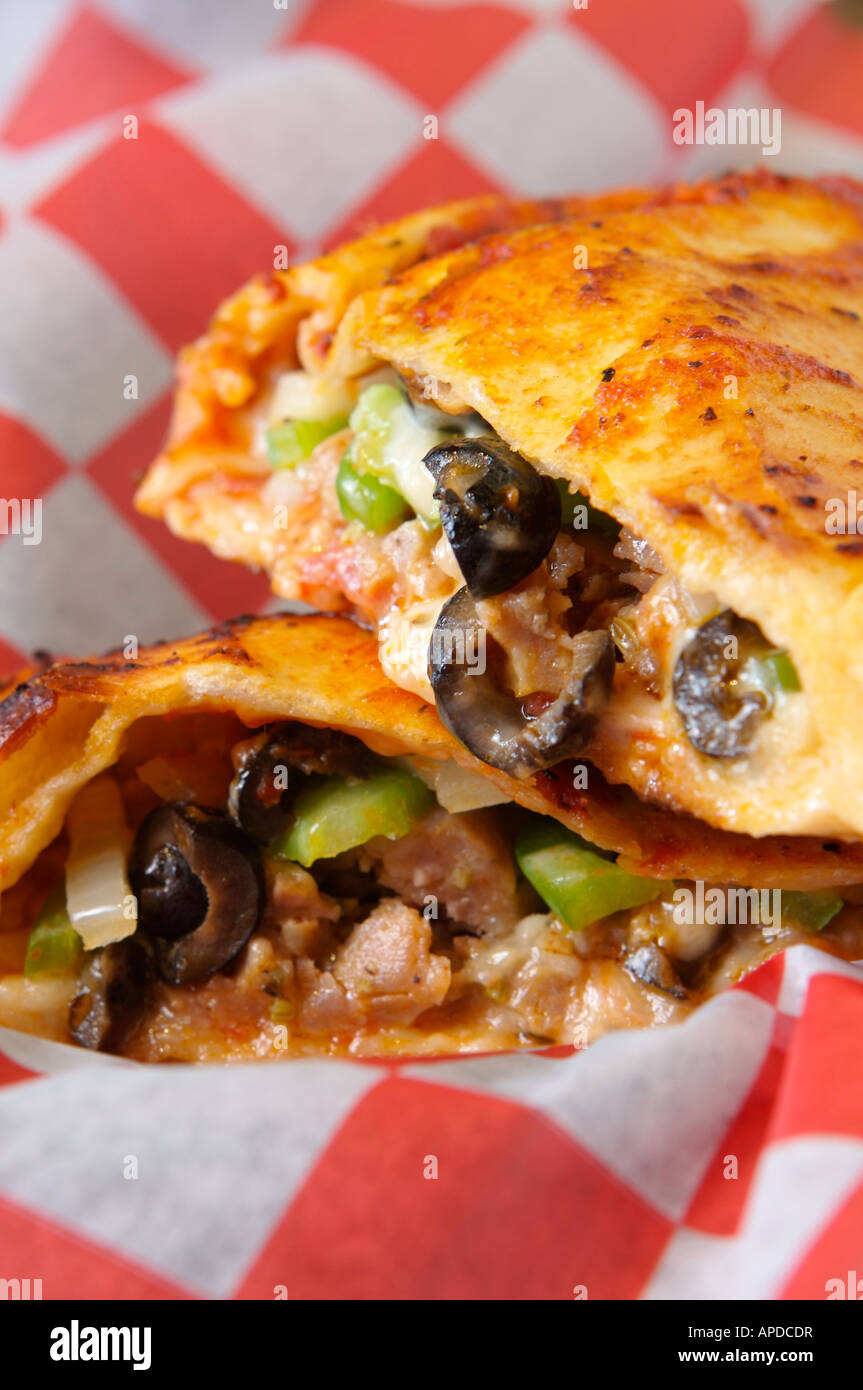 Calzone cut open in a red and white checkered print basket Stock Photo ...