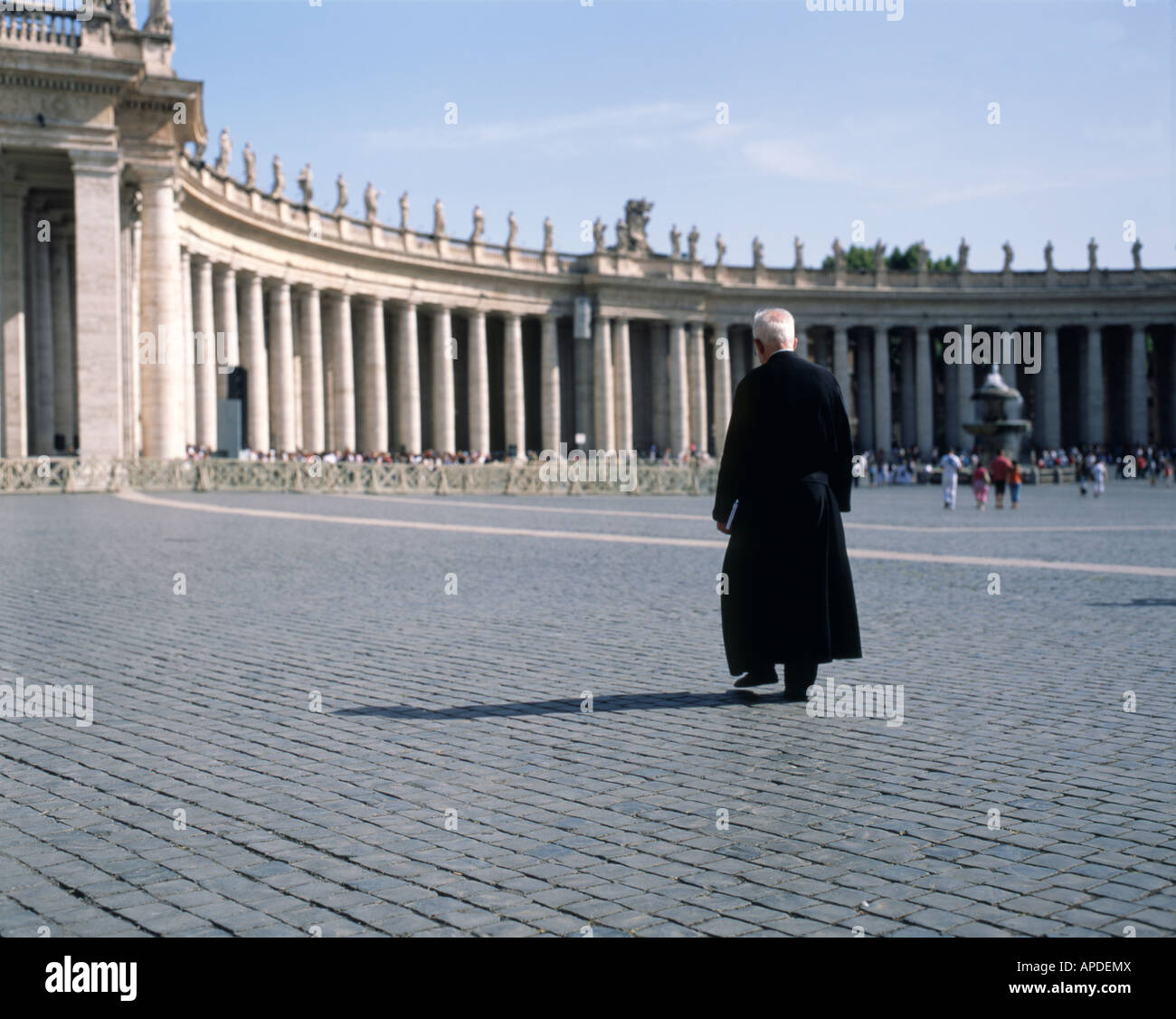 Black dressed single priest walking across St. Peter's Square with the ...