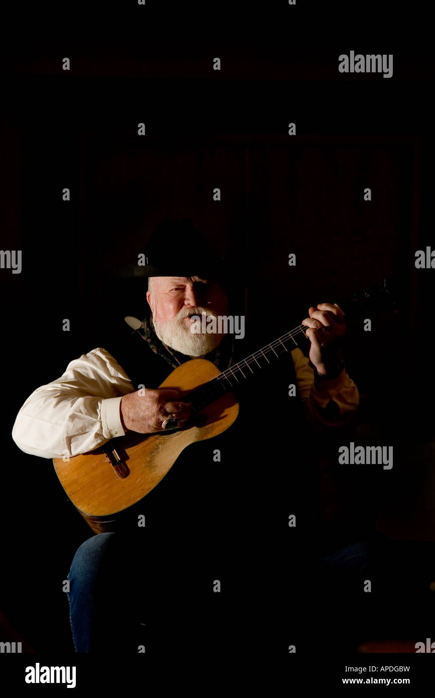 A cowboy sings along to his guitar at an evening party Stock Photo - Alamy